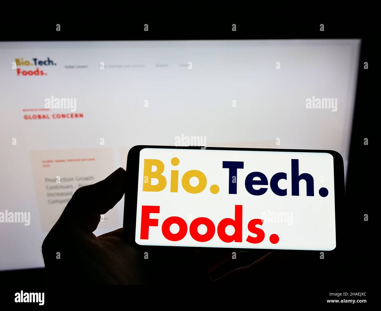 Person holding cellphone with logo of Spanish cultured meat company ...