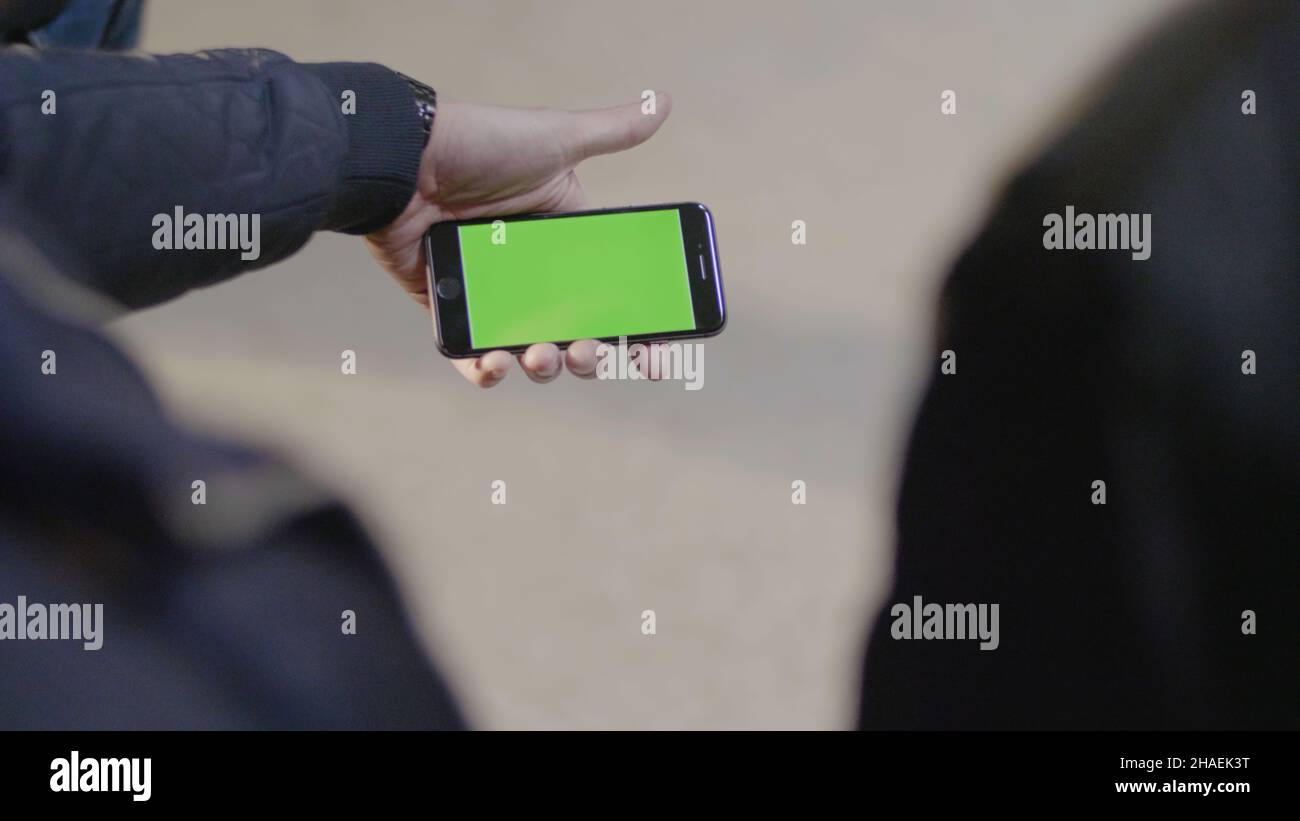 Man shows to his friend new app on his mobile phone. Phone with ...