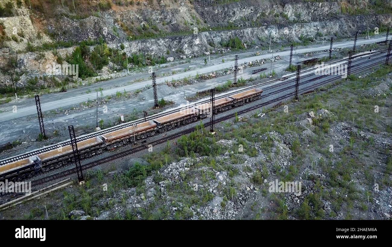Diesel locomotive is pushing dump-car filled with rubble stone in the ...