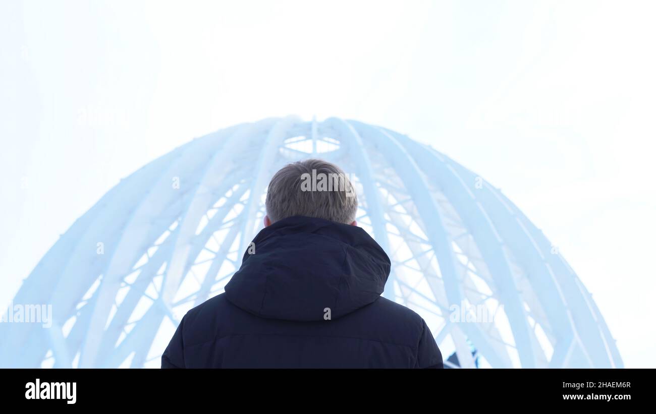 Back view of man looking at dome building. Media. View from back of man ...