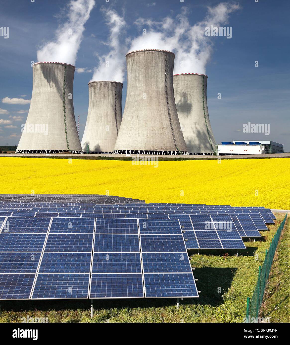 Nuclear power plant with golden flowering field of rapeseed and ...