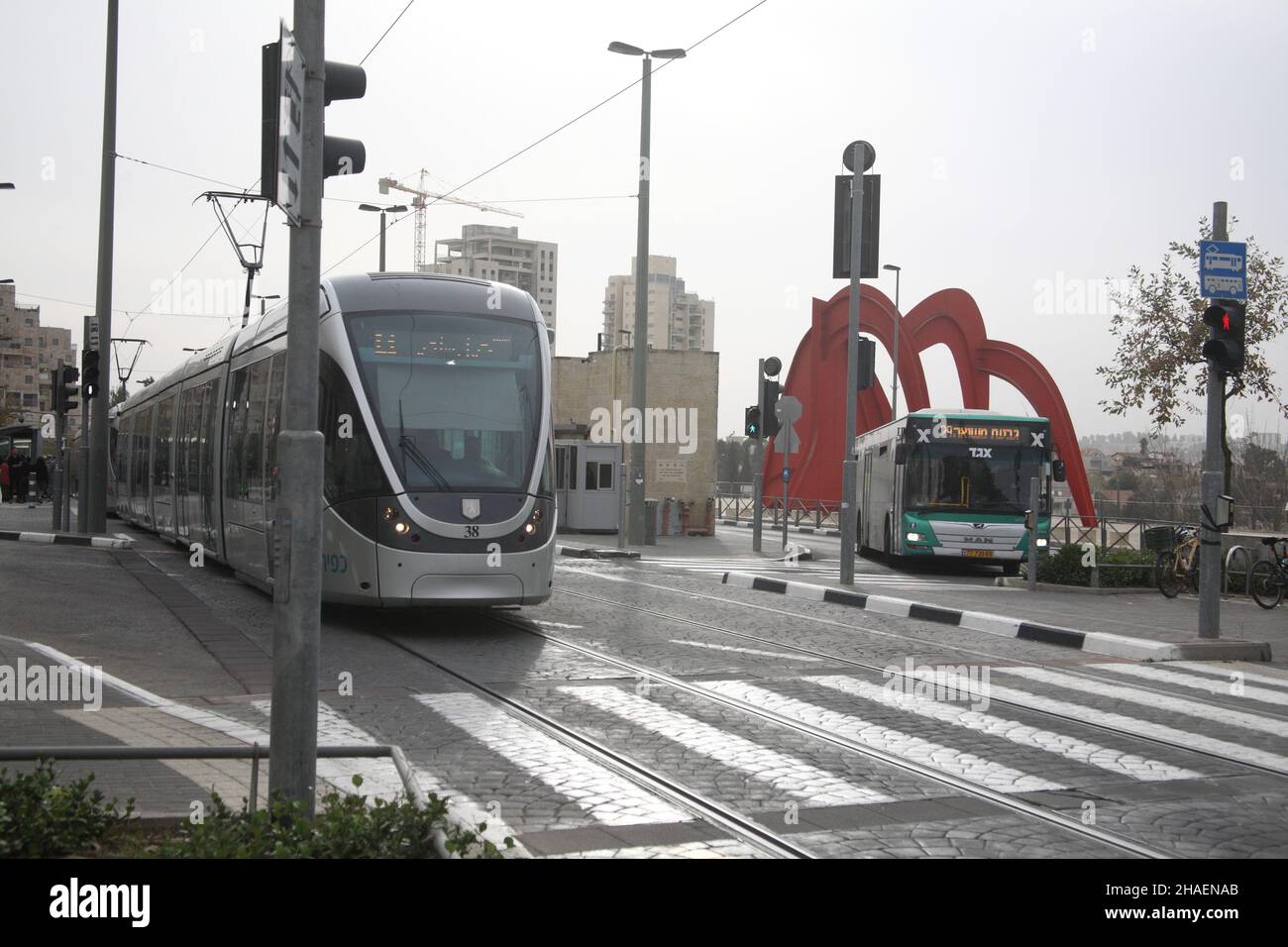Bus waits for the Light Rail to cross an intersection before moving on ...