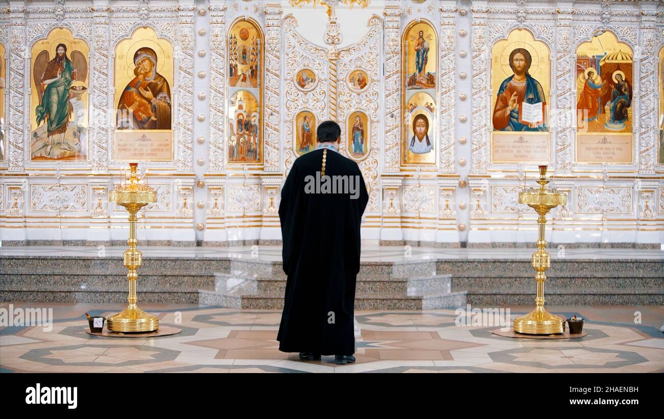 The Iconostasis inside an orthodox church. Video. Rear view of a priest ...