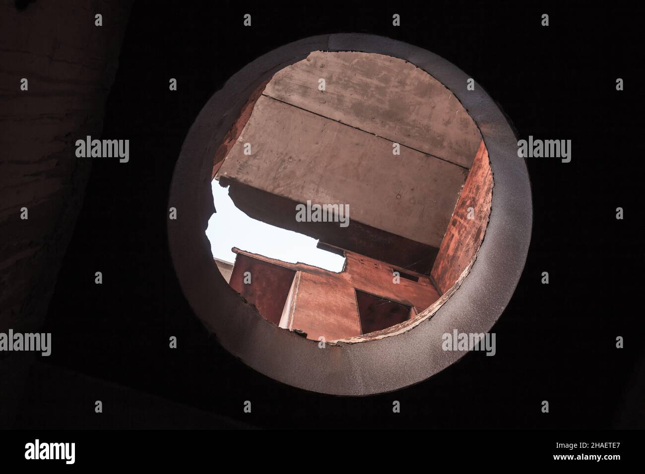 Grungy industrial interior with round light window in ceiling of the ...