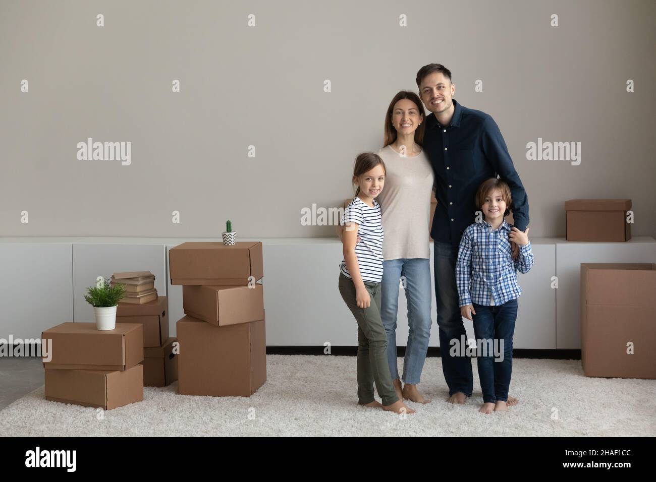 Happy bonding family moving into new apartment Stock Photo - Alamy