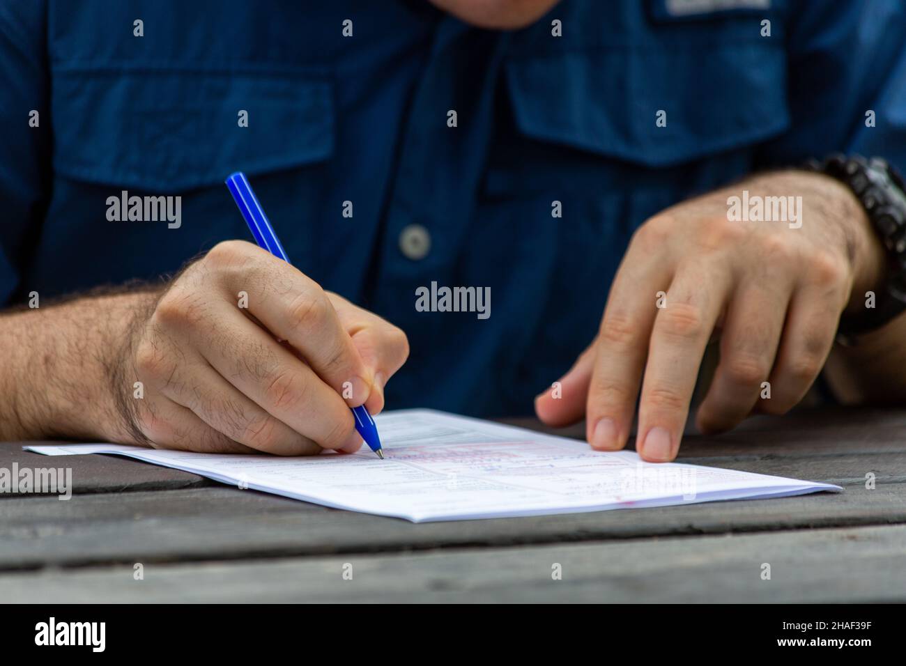 Young male hands filling out forms. Young man writing Stock Photo - Alamy