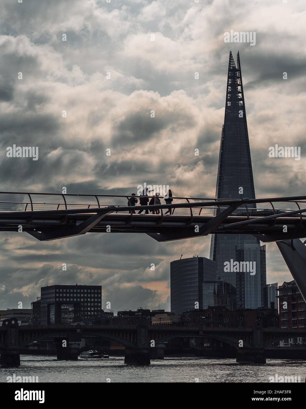 A vertical shot of the Shard surrounded by buildings and bridges in ...