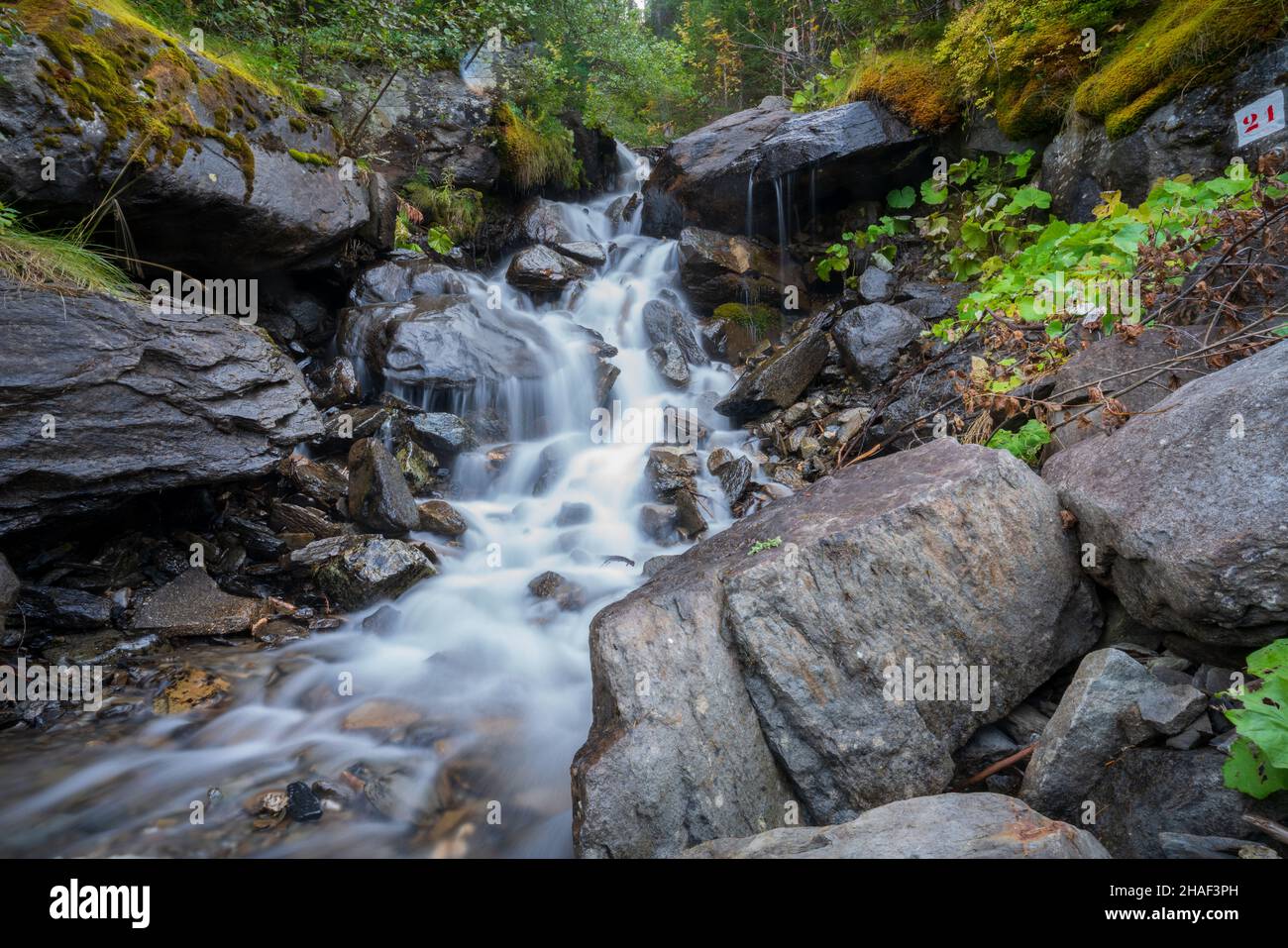 A mesmerizing view of a waterfall through large pieces of rocks in the ...