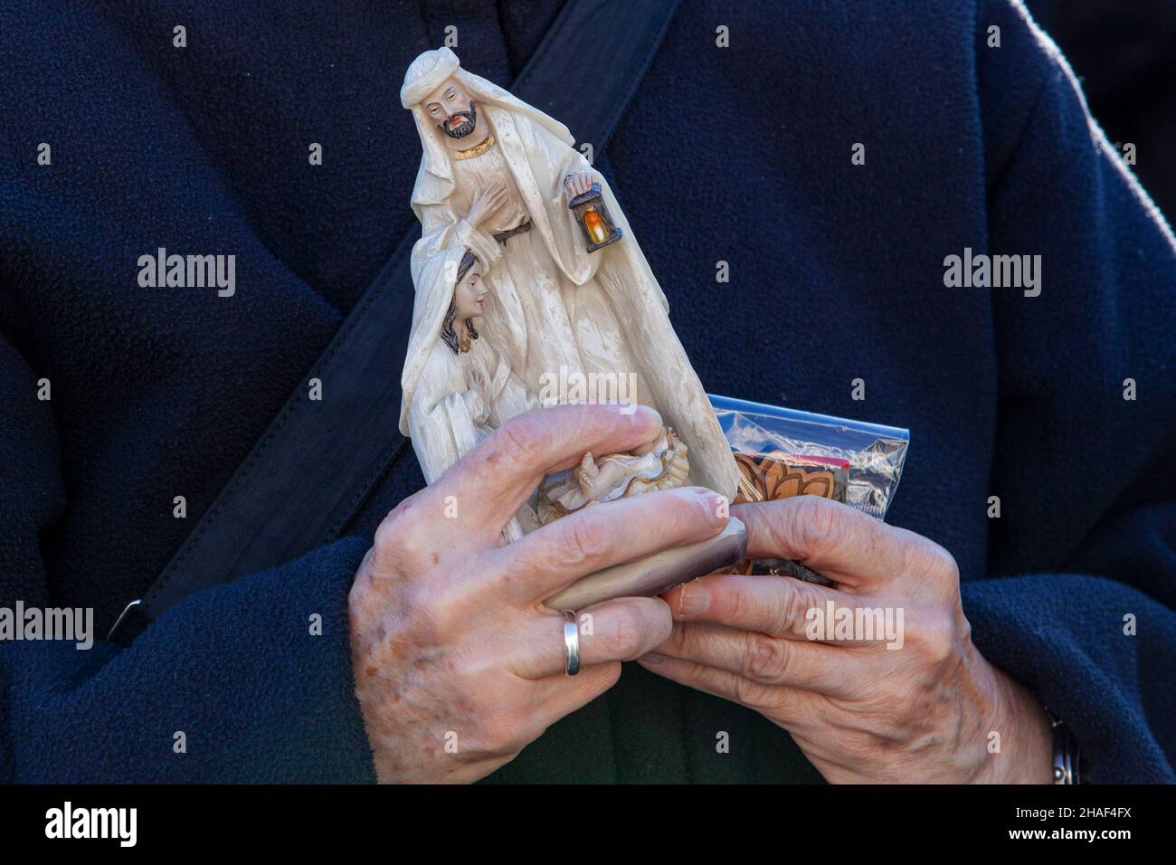 A devotee holds a statuette of the baby Jesus during the Sunday Angelus ...