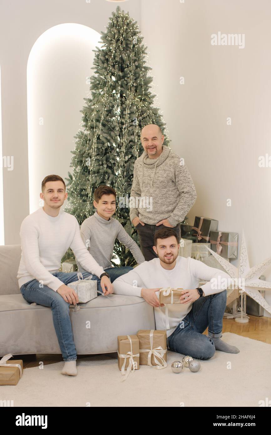 Young father with three sons. Big family at Christmas eve. Only man ...