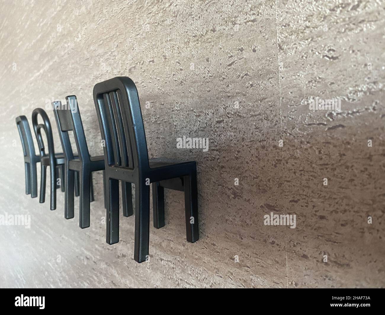 A perspective shot of mini decorative chairs hung on a wall Stock Photo ...