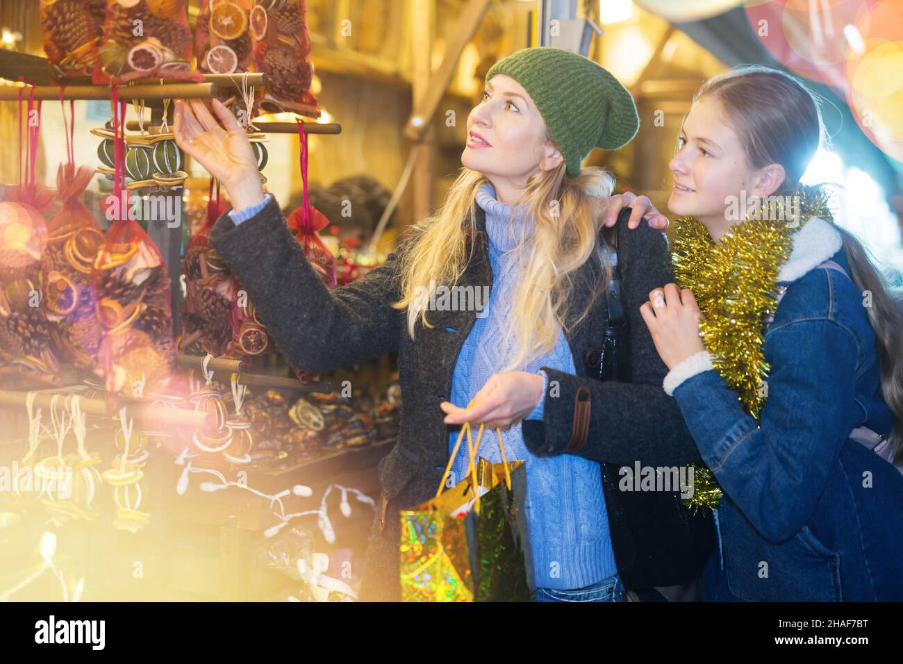 Teenage girl and her mother purchasing decorations at christmas market ...