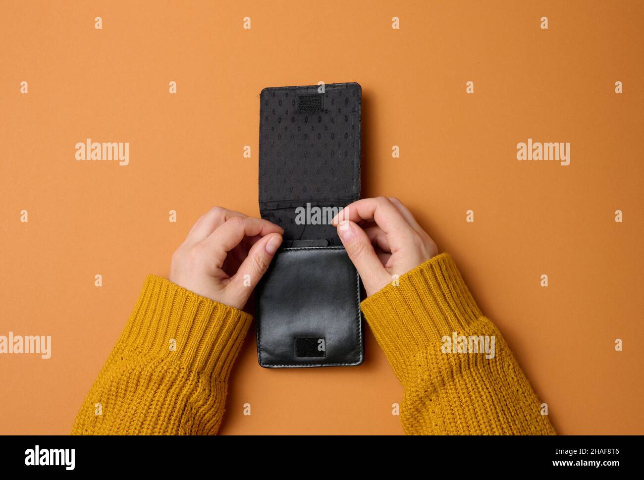 two female hands hold black leather open empty wallet for cash, top ...