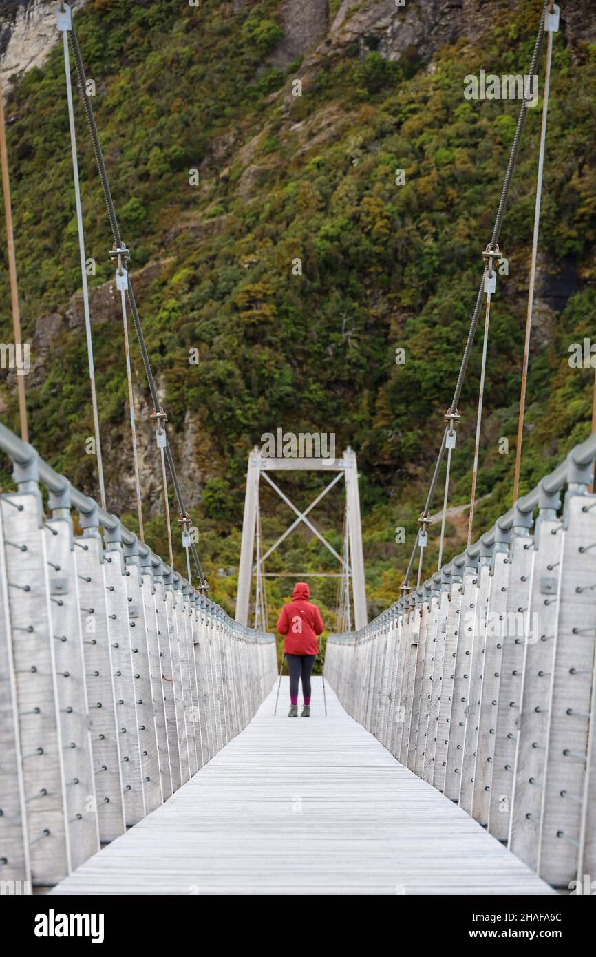 Female hiker walking across bridge in the mountains Stock Photo - Alamy