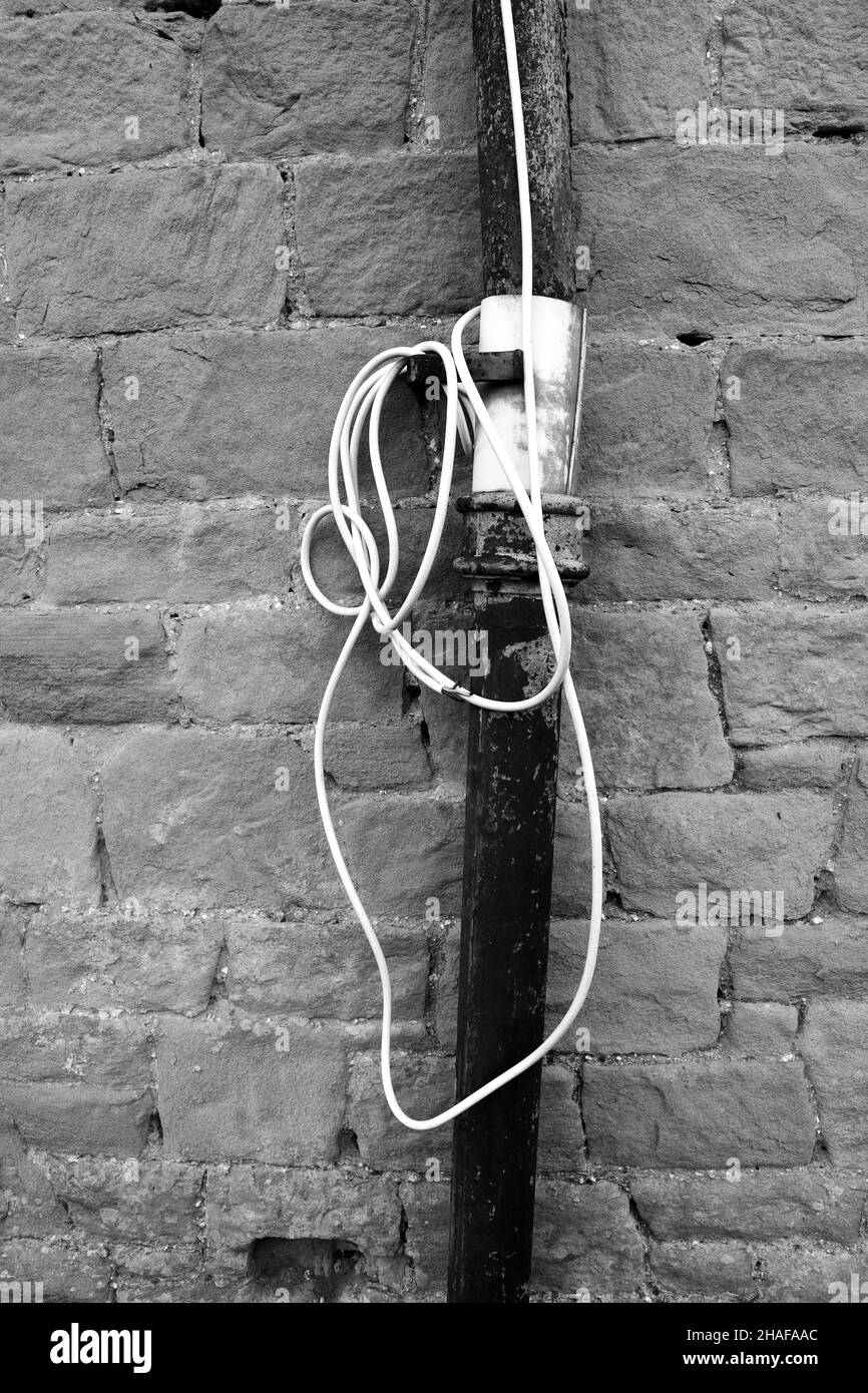 black and white photo of electrical cables against a stone wall Stock ...