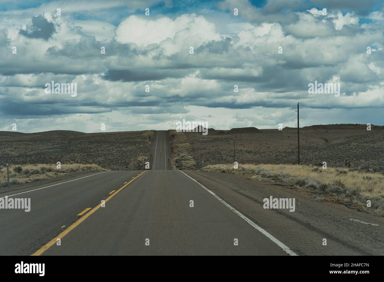 The empty U.S. 95 asphalt highway in Eastern Oregon under a blue sky ...