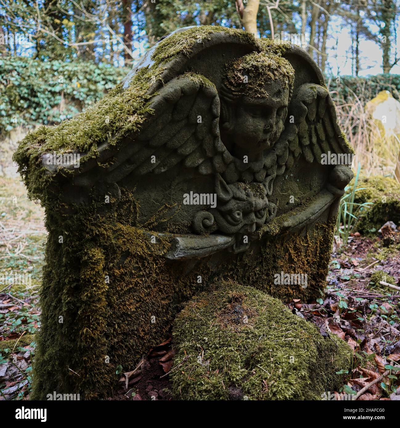 a grave with a cherub engraving in a moody setting Stock Photo - Alamy