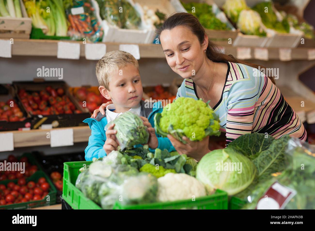 Little boy with his mother choosing fresh broccoli at vegetable ...