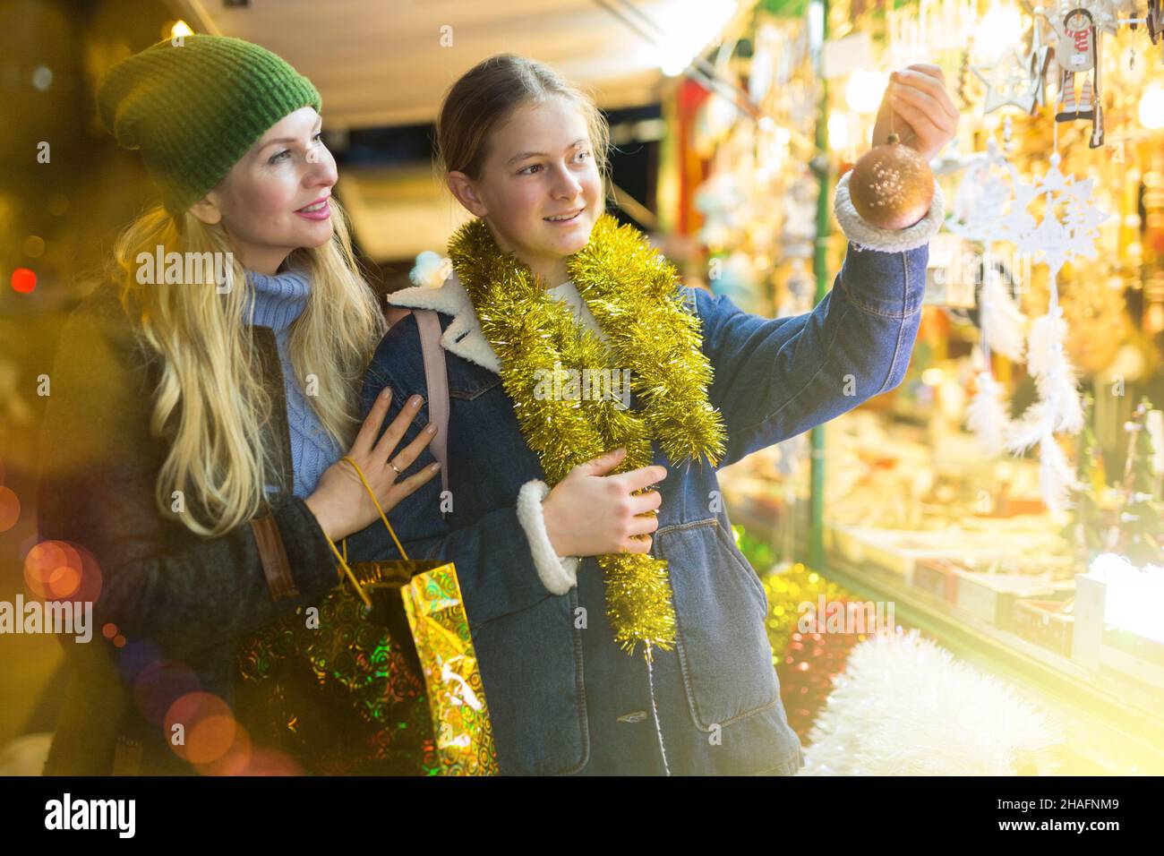 Teenage girl and her mother purchasing decorations at christmas market ...