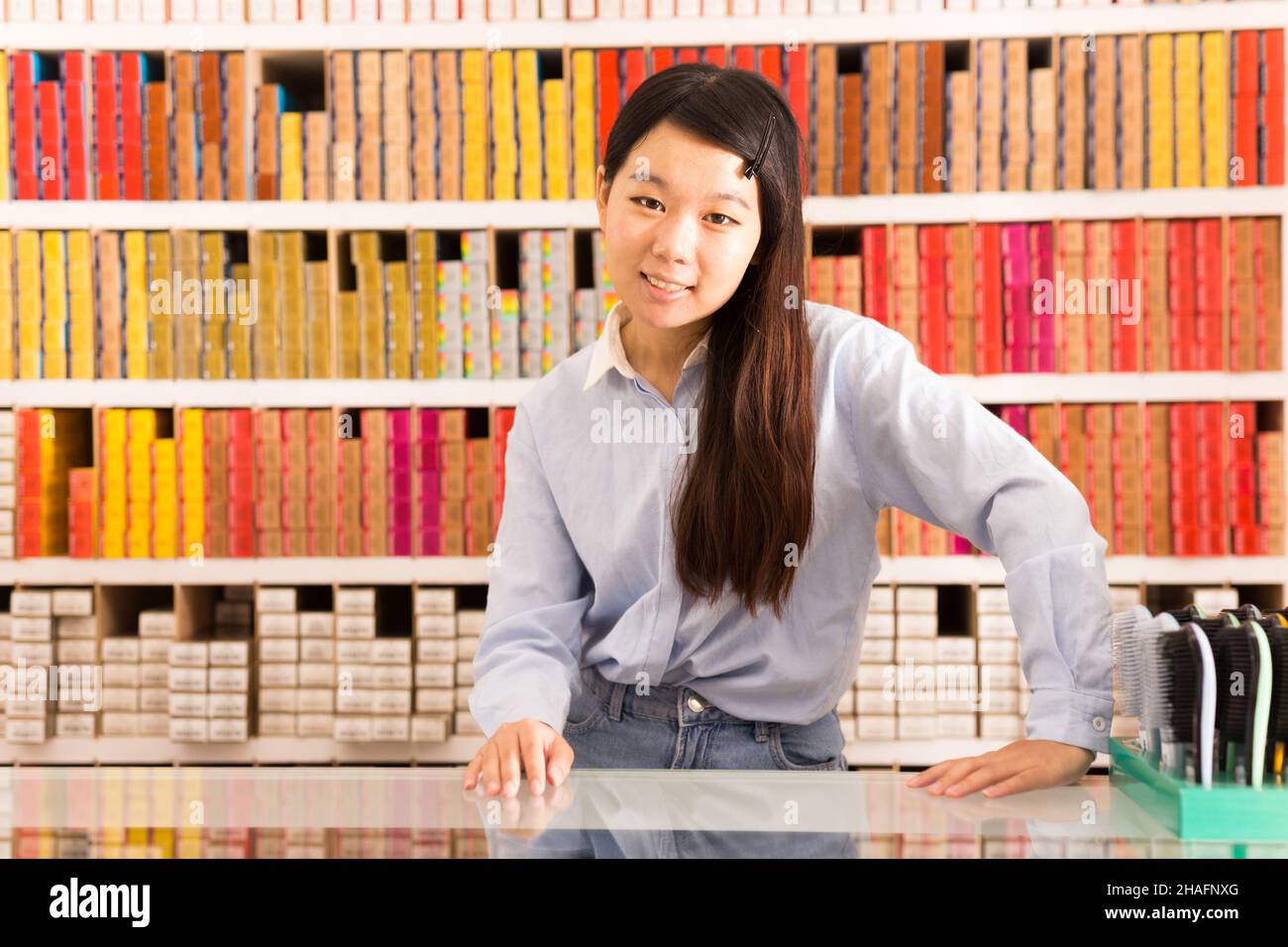 Attractive Asian girl consultant selling hair dye products in ...