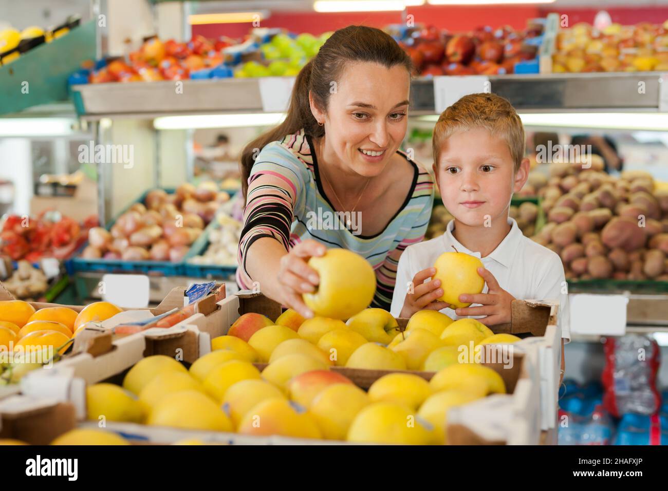 Little boy with his mother choosing fresh pears and apples at fruit ...