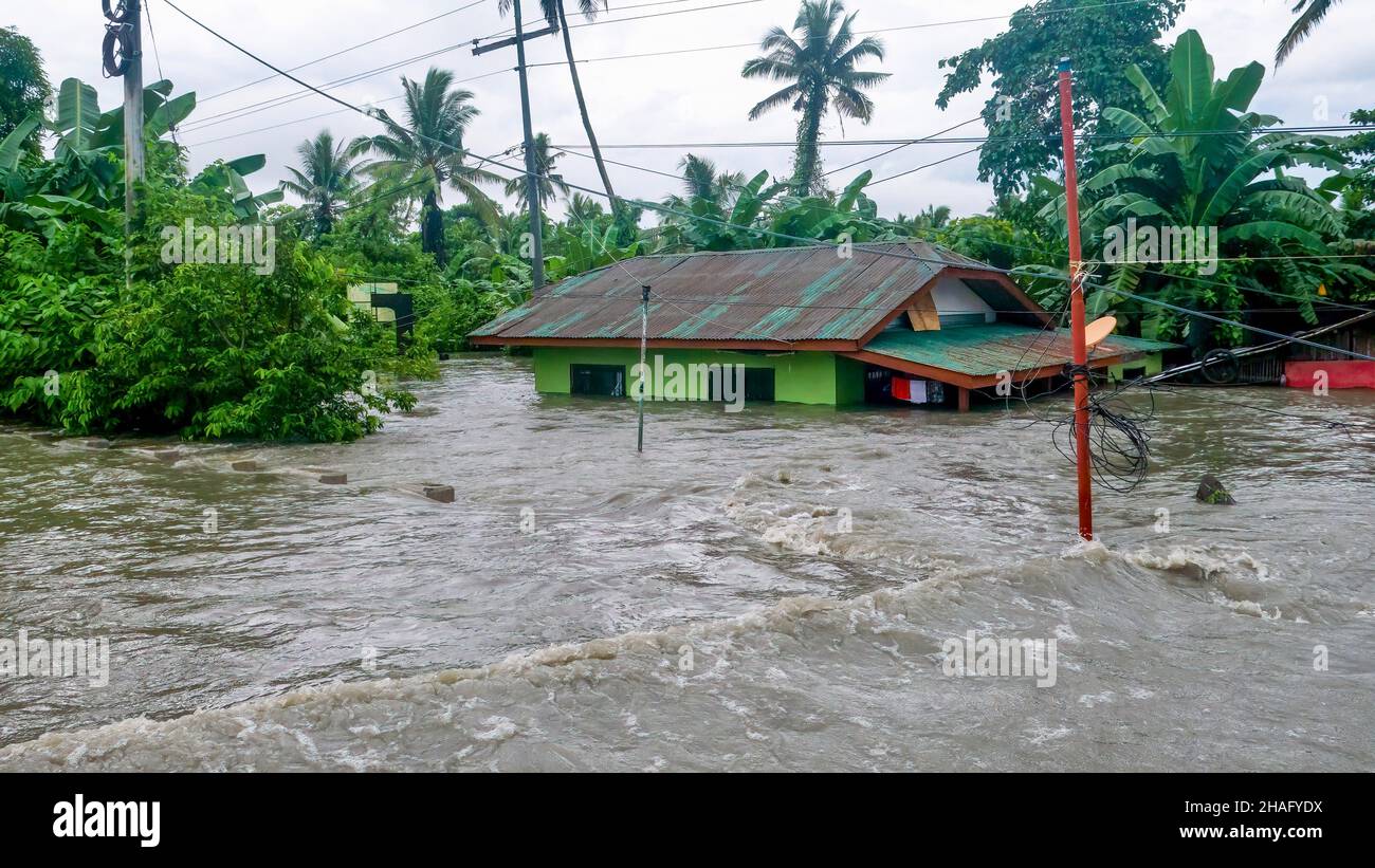 A rural house is nearly submerged by deep floodwater rushing off the ...
