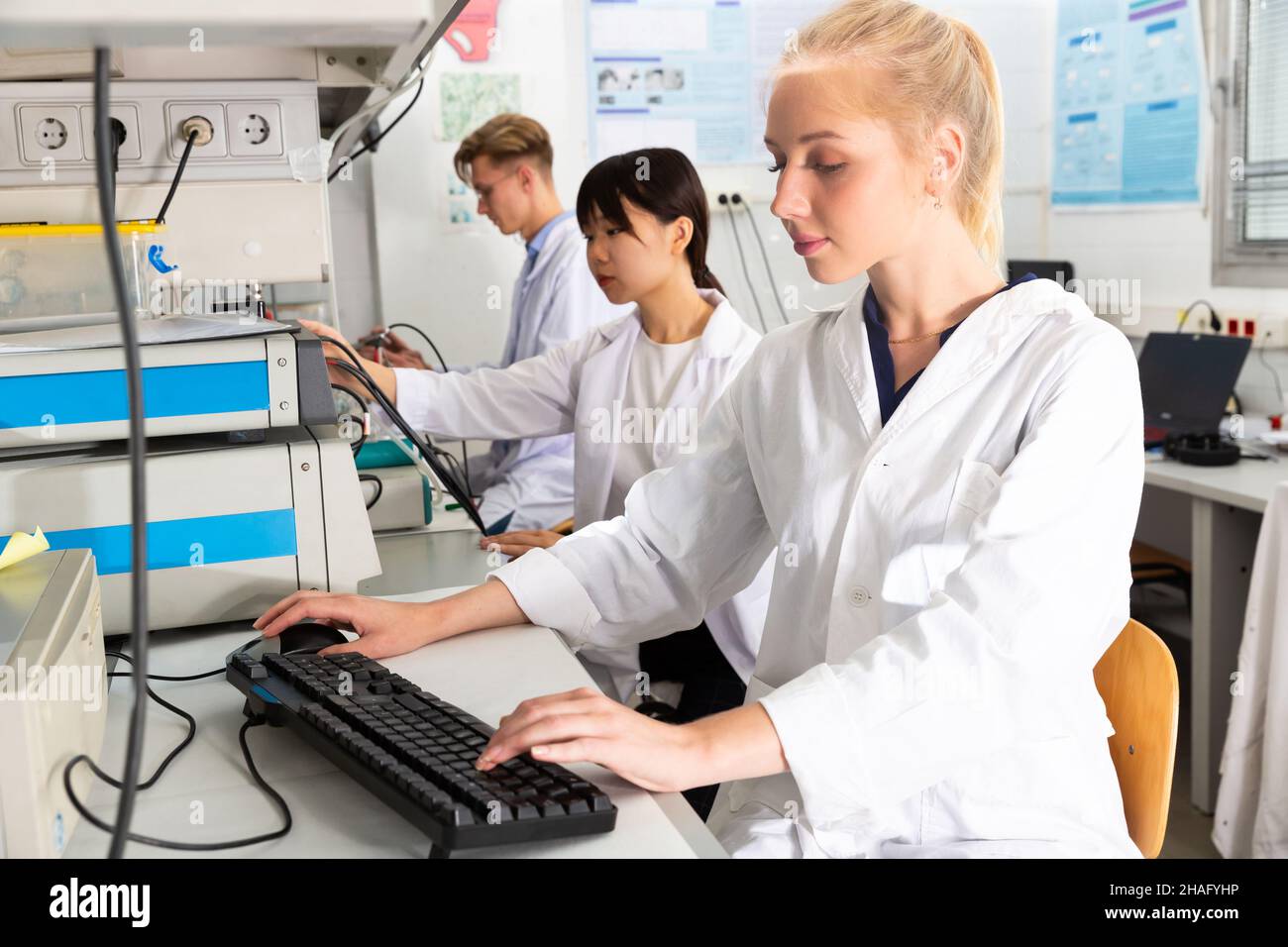 Portrait of male and female scientists in white coats working at ...
