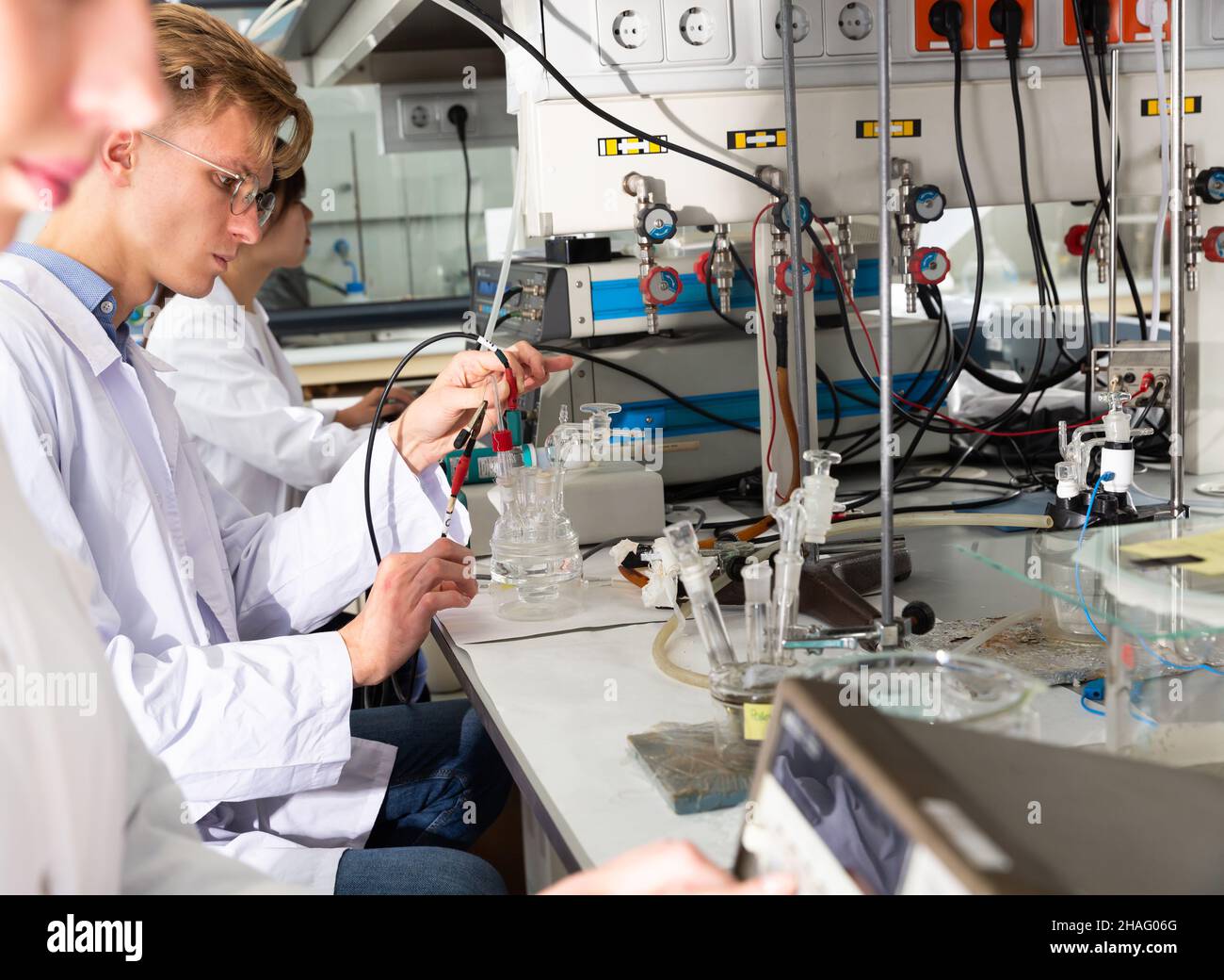 Portrait of intelligent male student working with his coursemates in ...