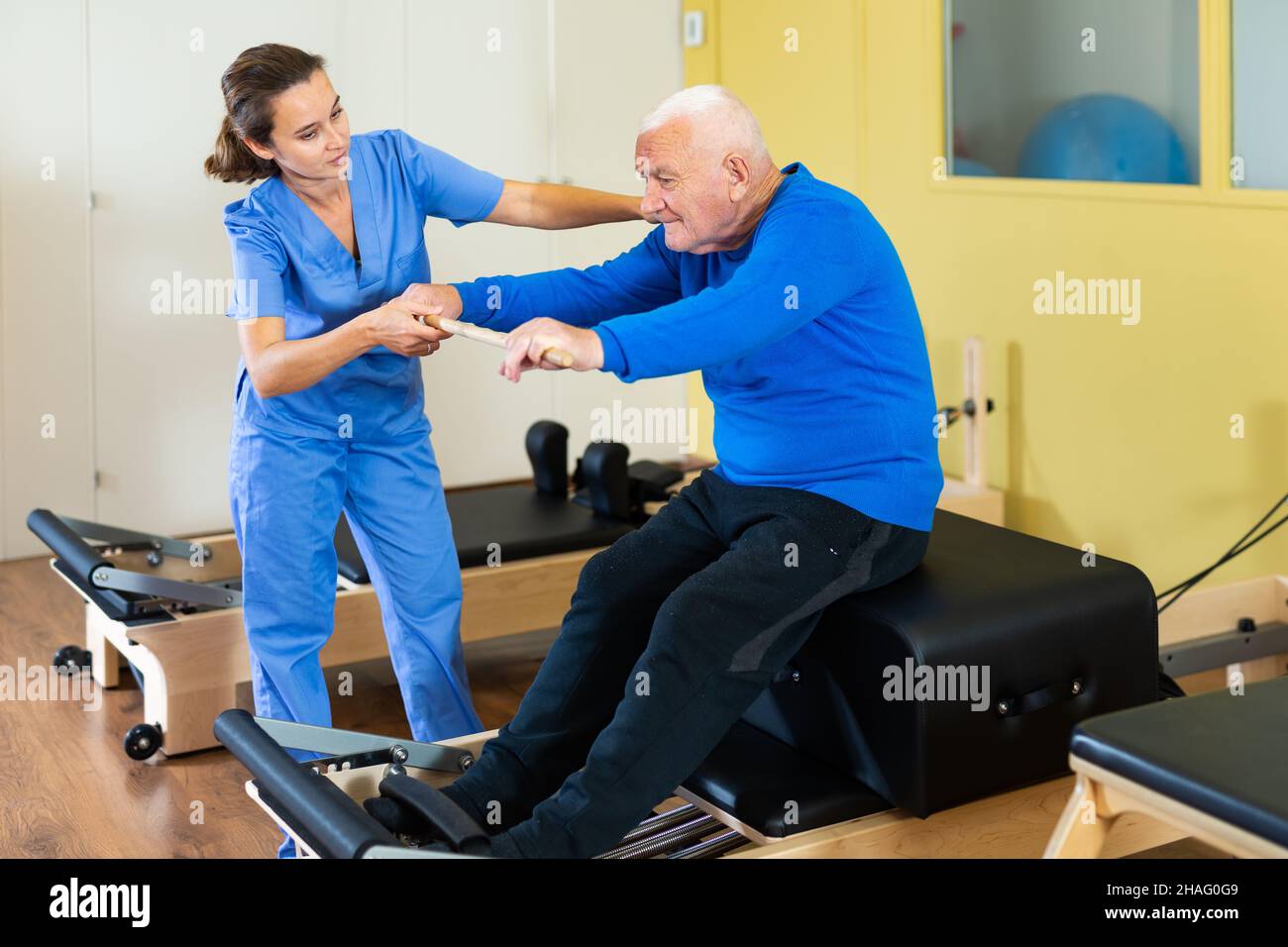 Medical professional helps and monitors the difficulty of Pilates ...