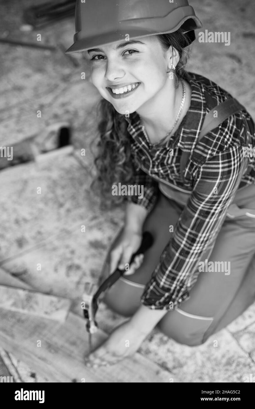 Portrait of a cute kid posing as a carpenter, with a hammer. working as ...