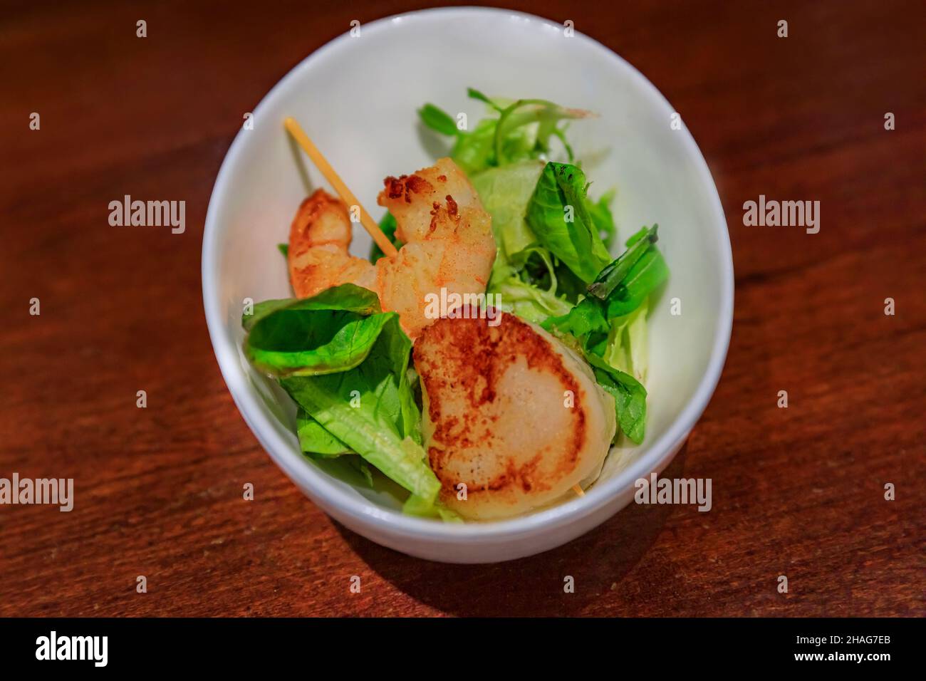 Traditional Spanish pintxos of grilled shrimp and scallop on a bed of ...