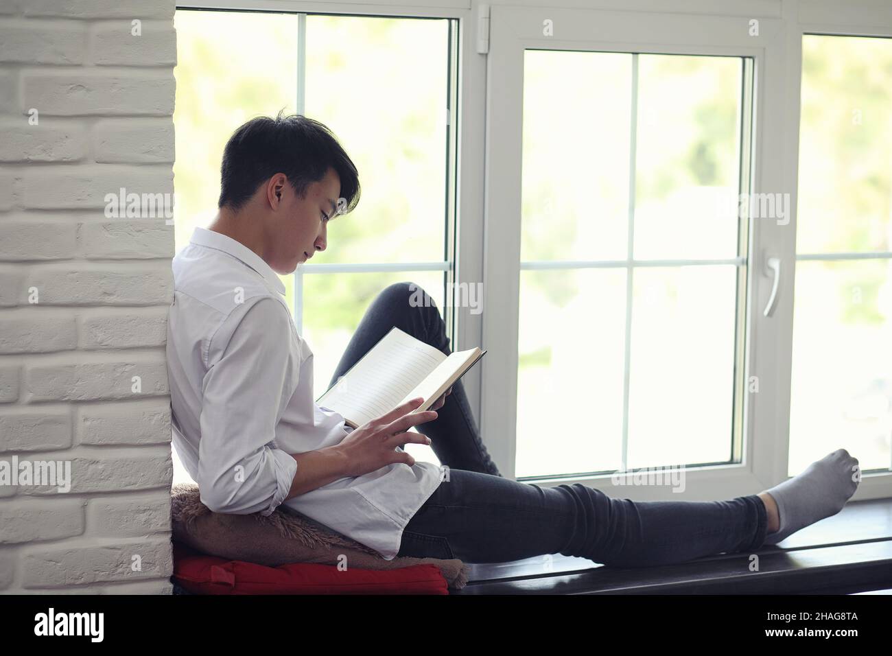 Asian young man student with books in hands Stock Photo - Alamy