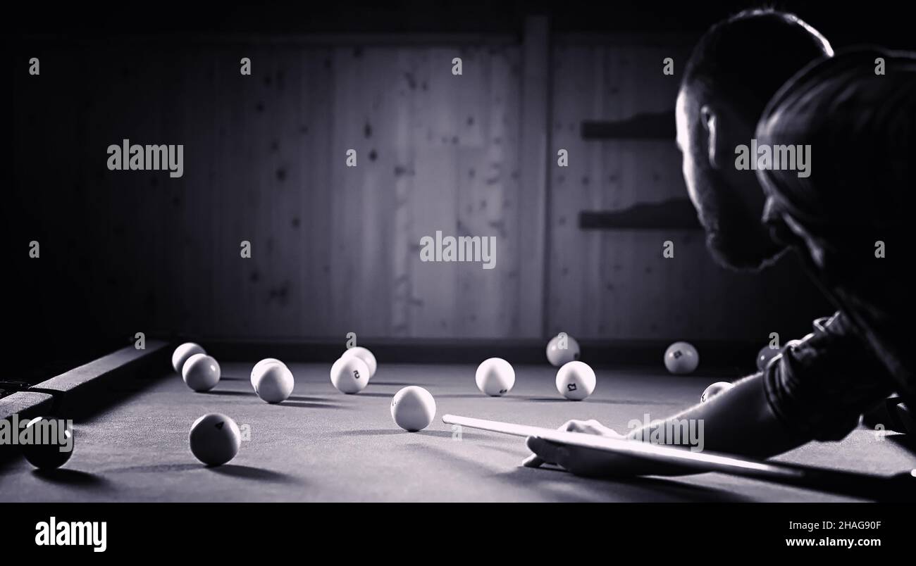 A man with a beard plays a big billiard. Party in 12-foot pool ...