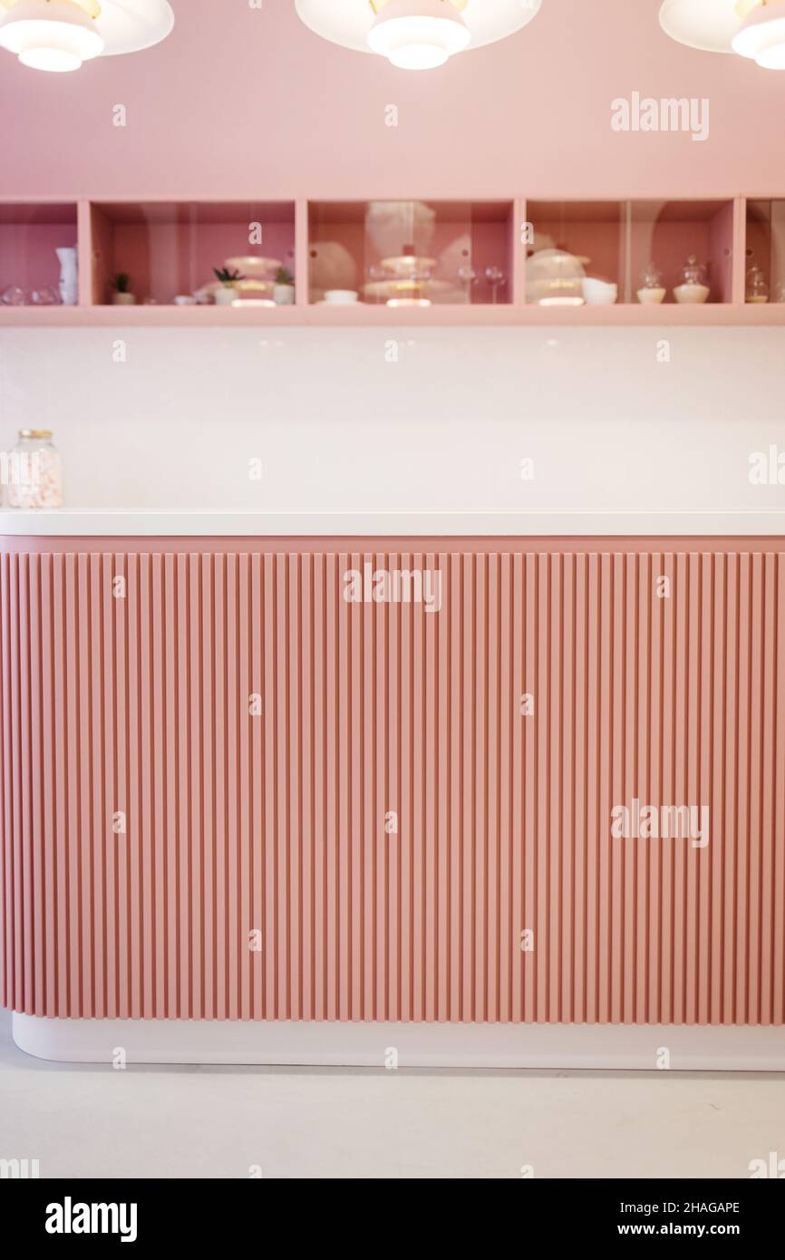 Stylish pink kitchen interior with dining table and lamps Stock Photo ...