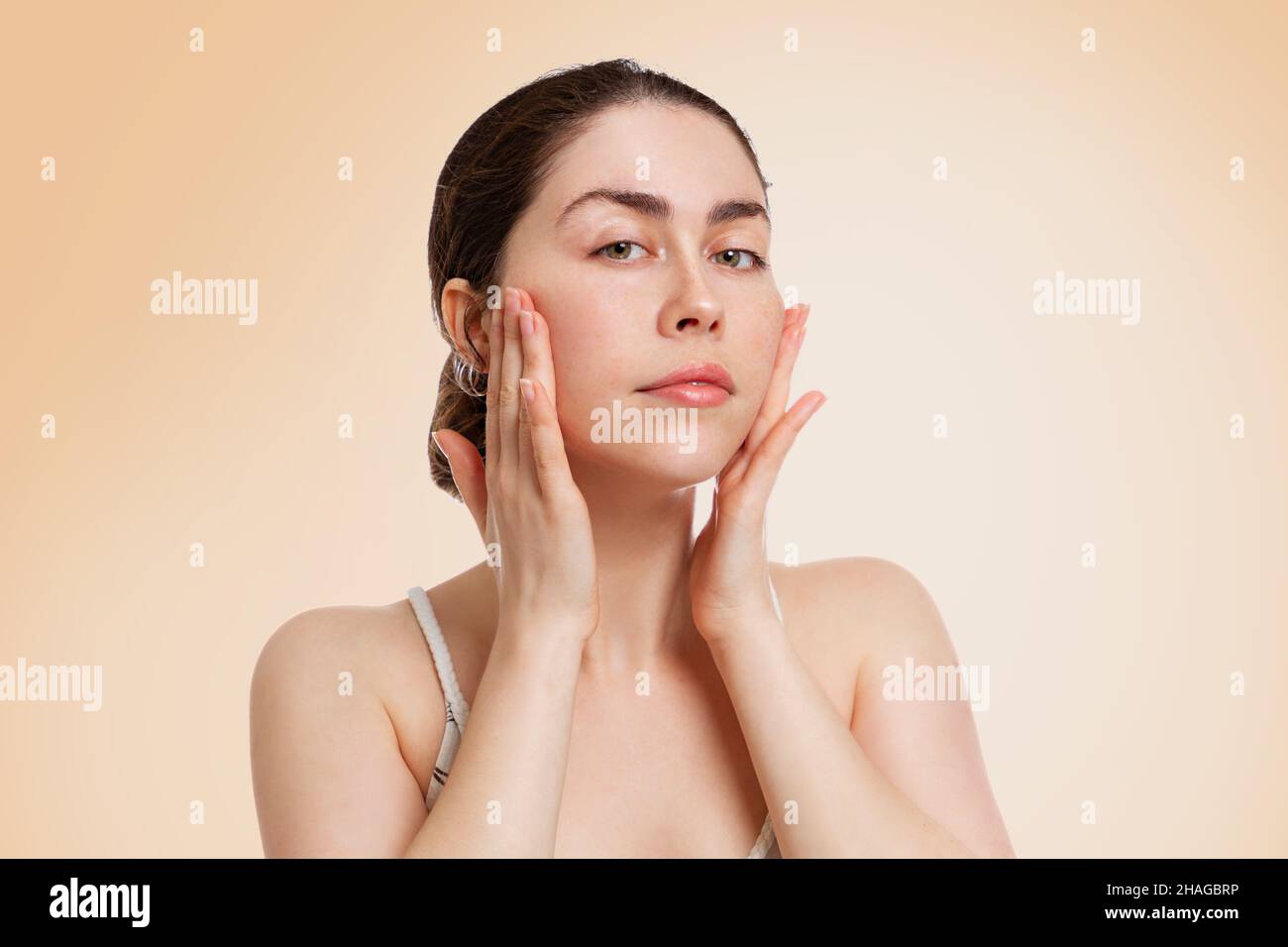 Portrait of a young woman with beautiful skin, pulling the skin on her ...