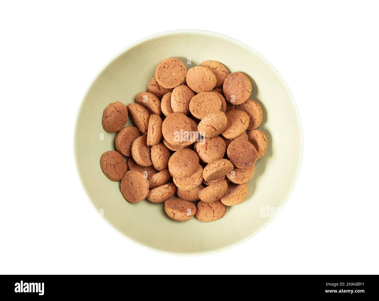 Traditional Dutch candy pepernoot in green bowl, isolated on white ...