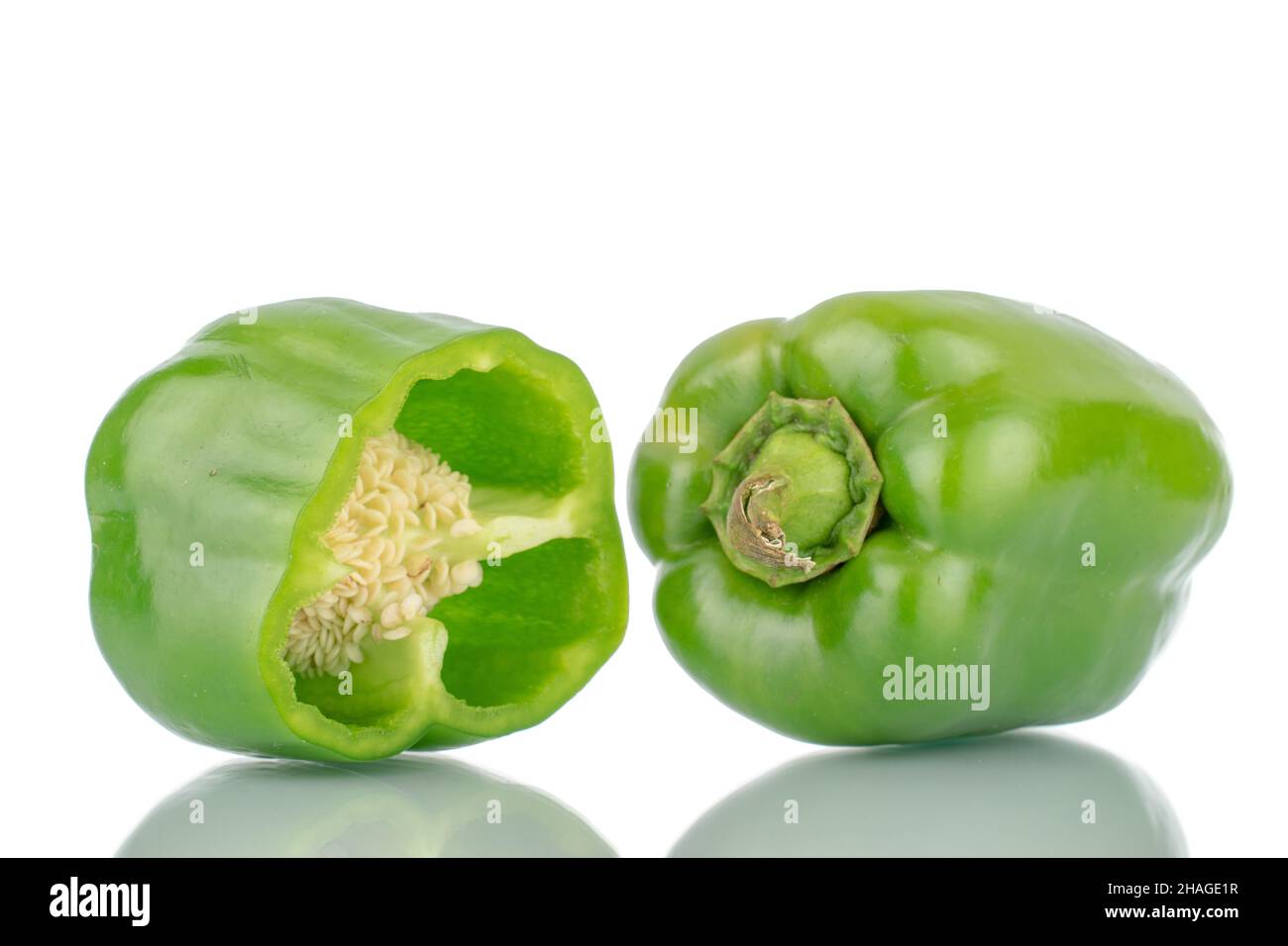 One whole organic, sweet green peppers and one half, close-up, isolated ...