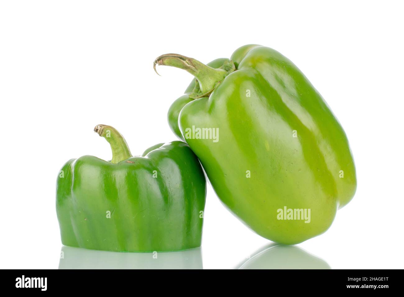 One whole organic, sweet green peppers and one half, close-up, isolated ...
