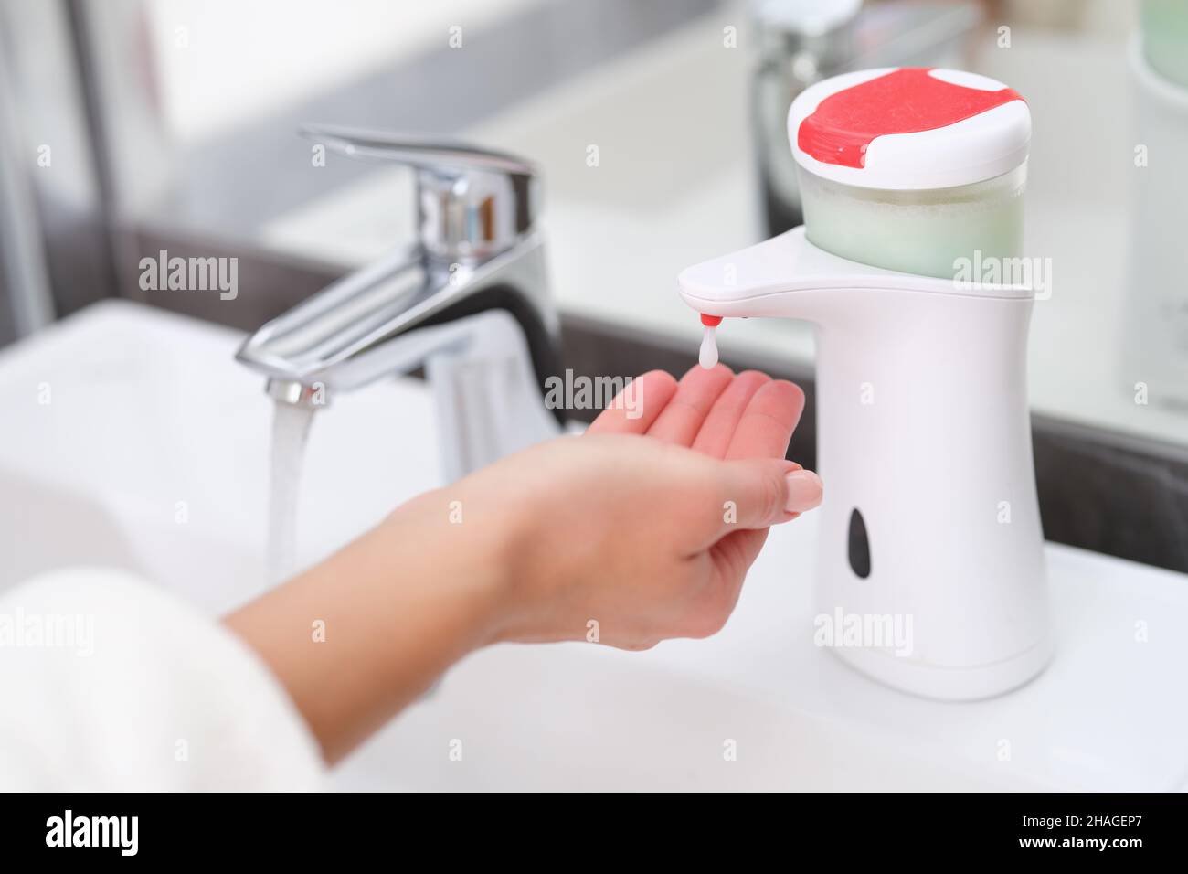A drop of soap from a dispenser drips onto a woman's hand Stock Photo ...