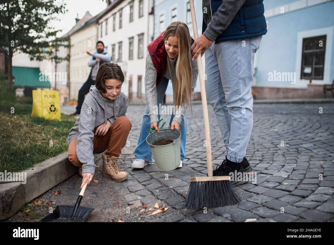 Diverse group of happy volunteers cleaning up street, community service ...