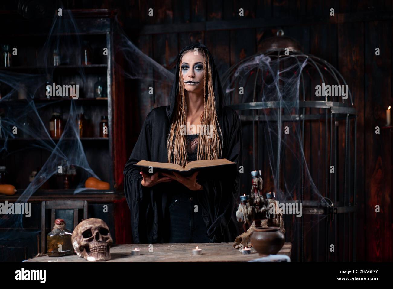 Halloween concept. Witch dressed black hood with dreadlocks standing ...