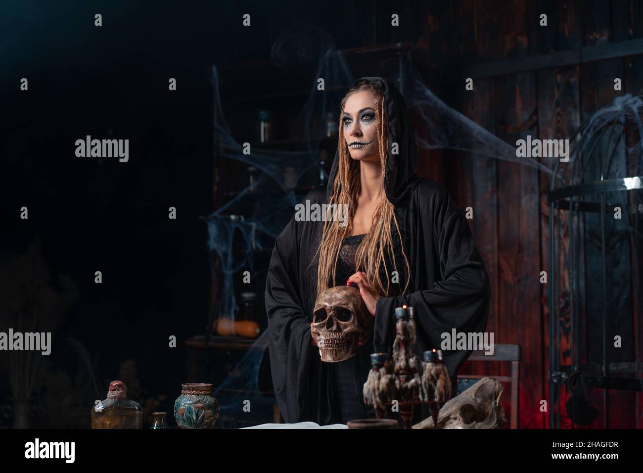 Halloween concept. Witch portrait close up with dreadlocks holding ...