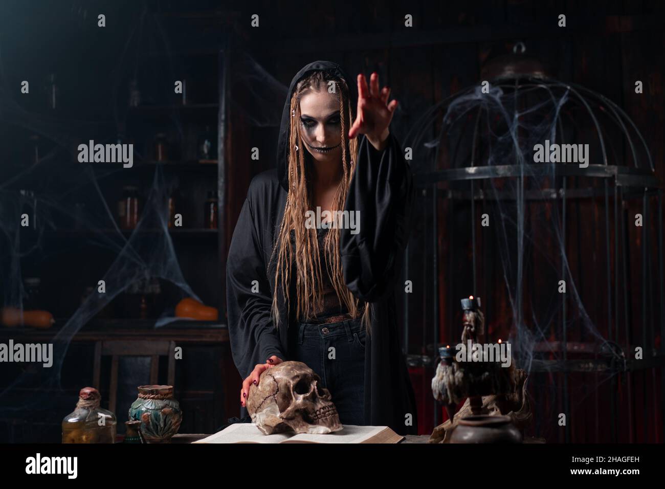 Halloween concept. Witch portrait close up with dreadlocks holding ...