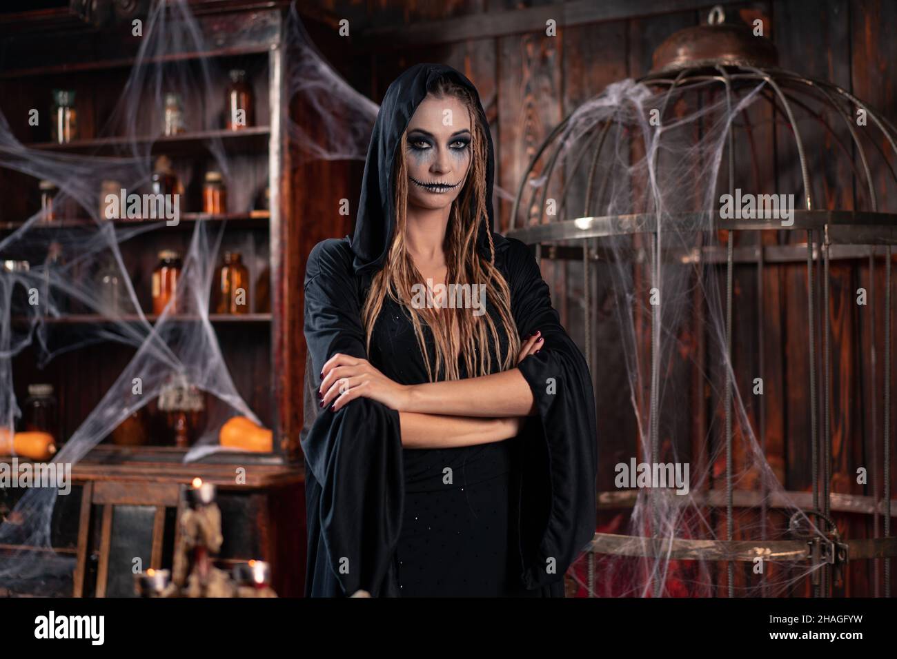 Halloween concept. Witch dressed black hood with dreadlocks standing ...