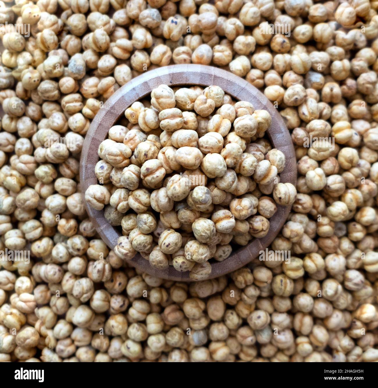 Roasted yellow chickpeas in a wooden bowl, chickpeas full the frame ...