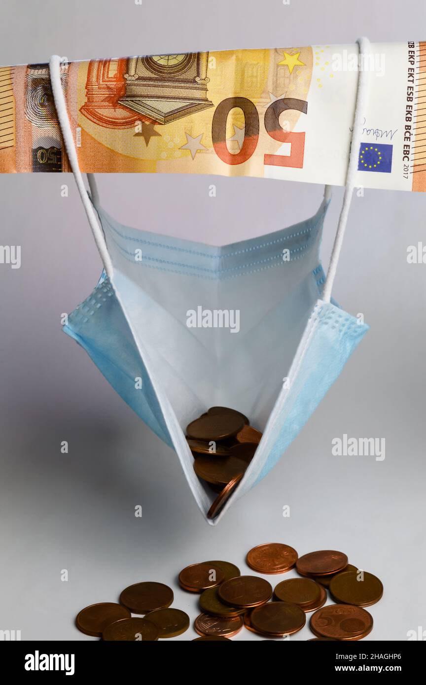 The economic effect of the pandemic - A 50 euro banknote holds up a ...