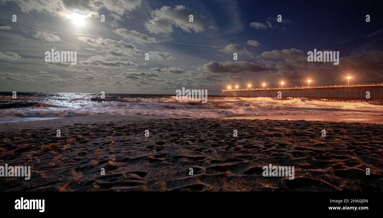 Beautiful seascape and a pier at night under a cloudy sky Stock Photo ...