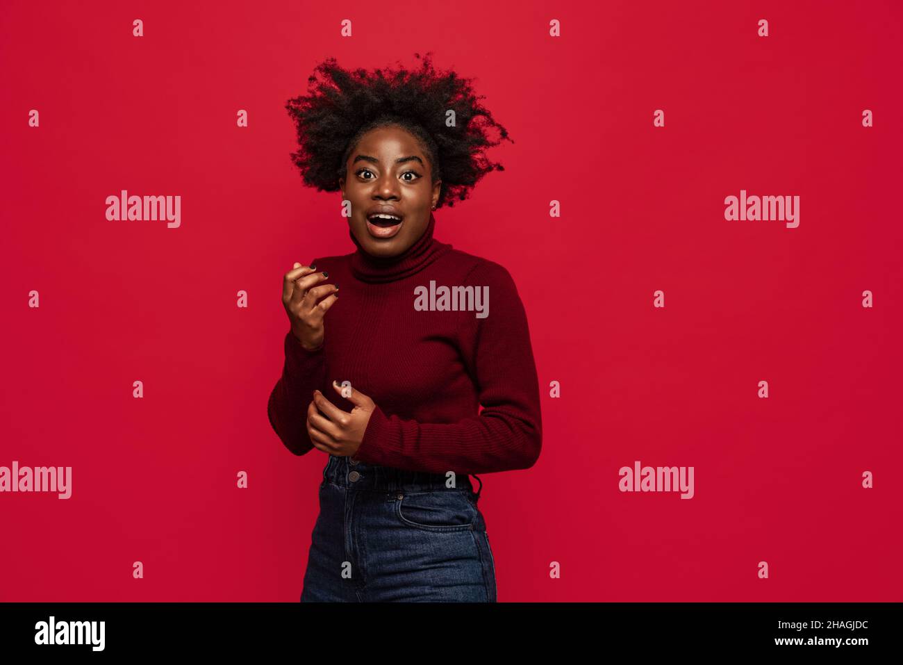 Portrait of dark skinned young pretty girl wondering isolated on dark ...