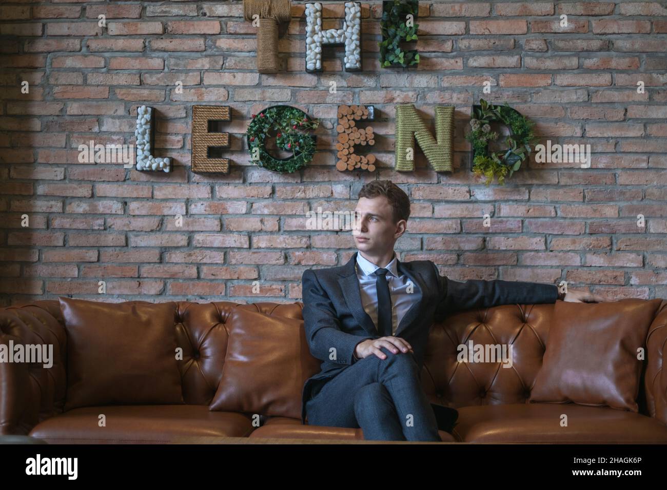 Portrait of young caucasian business man in formal suit sitting on ...