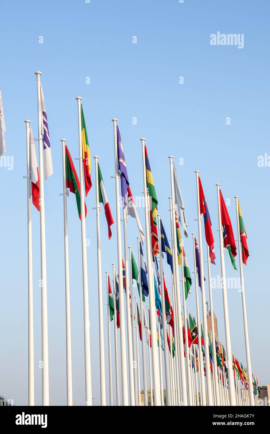 Vertical shot of tall poles with world countries flags against a clear ...